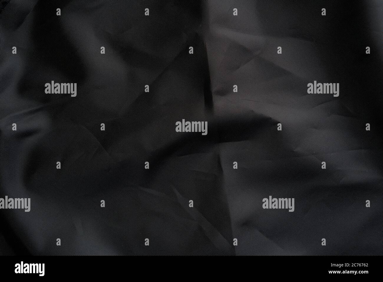 Abstract black synthetic material with wrinkles and wrinkled folds. Old ...