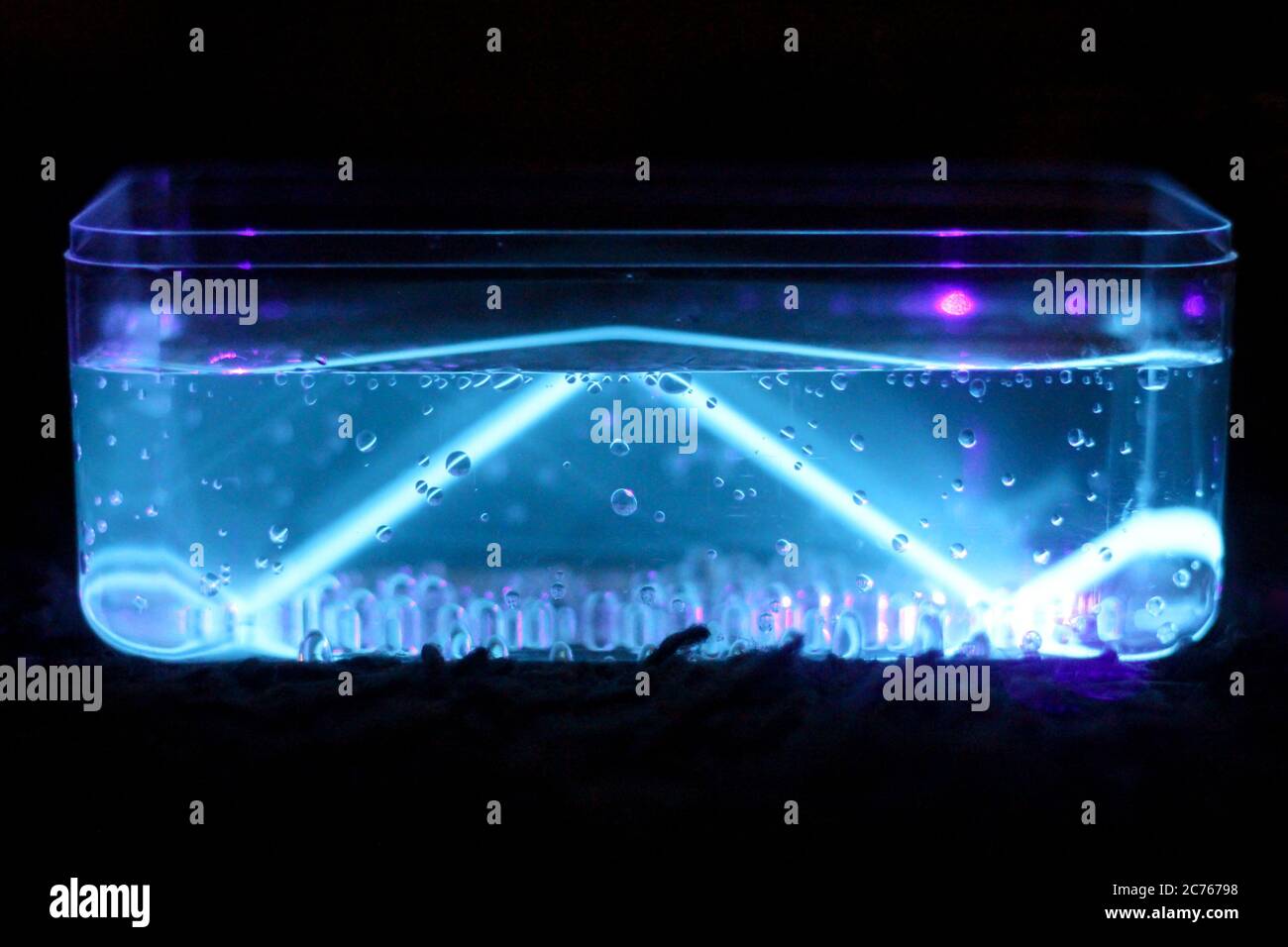 Violet or purple 405nm laser beam fluorescing quinine in tonic water ...