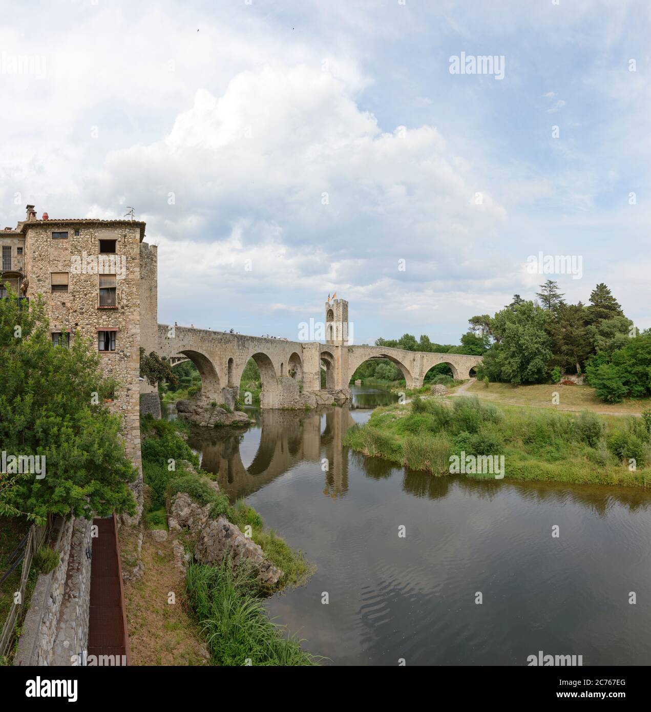 Scenic panoramic view of ancient bridge across Fluvia River in medieval ...