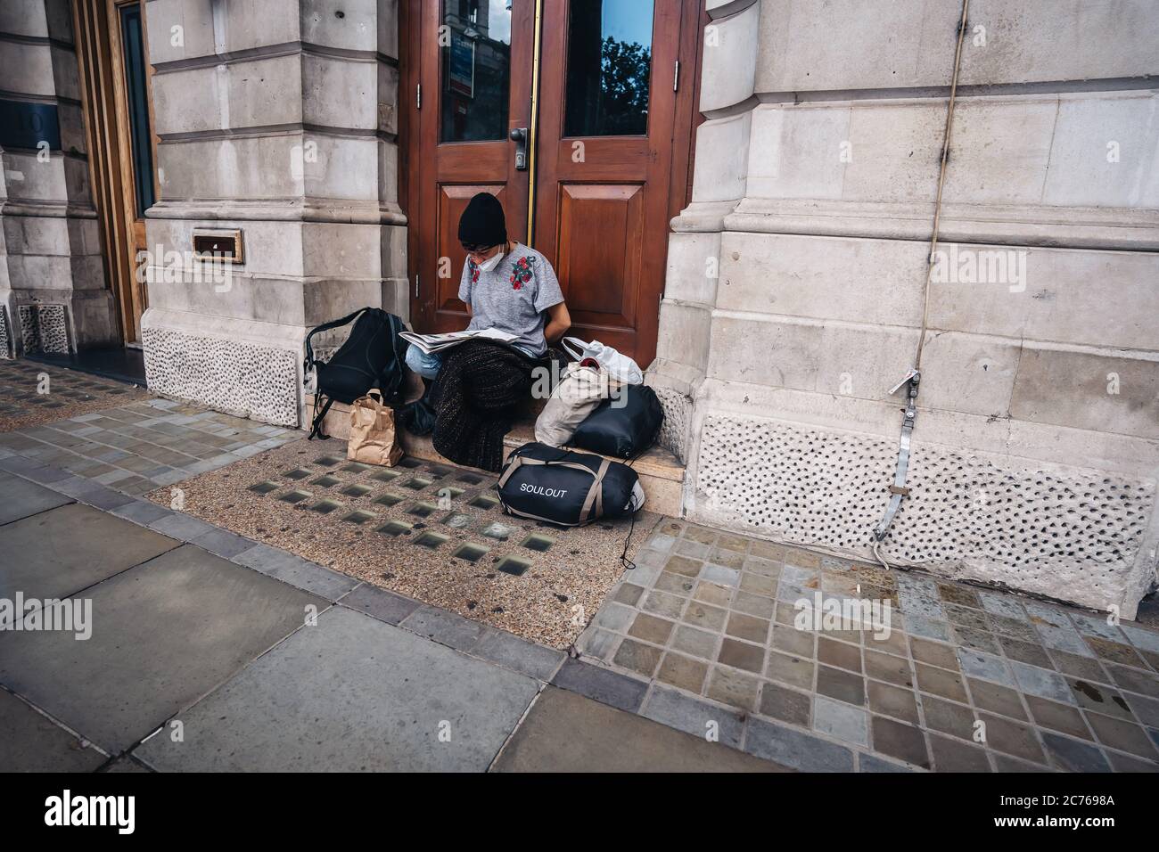 London / UK - 07/11/2020: Homeless lady sitting on the pavement ...