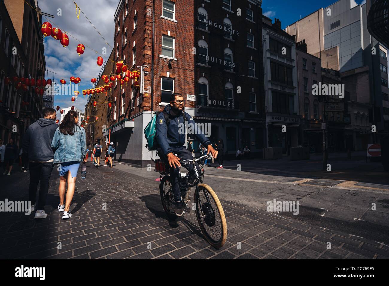 London / UK - 07/11/2020: Delivroo courier on the bike delivering food ...