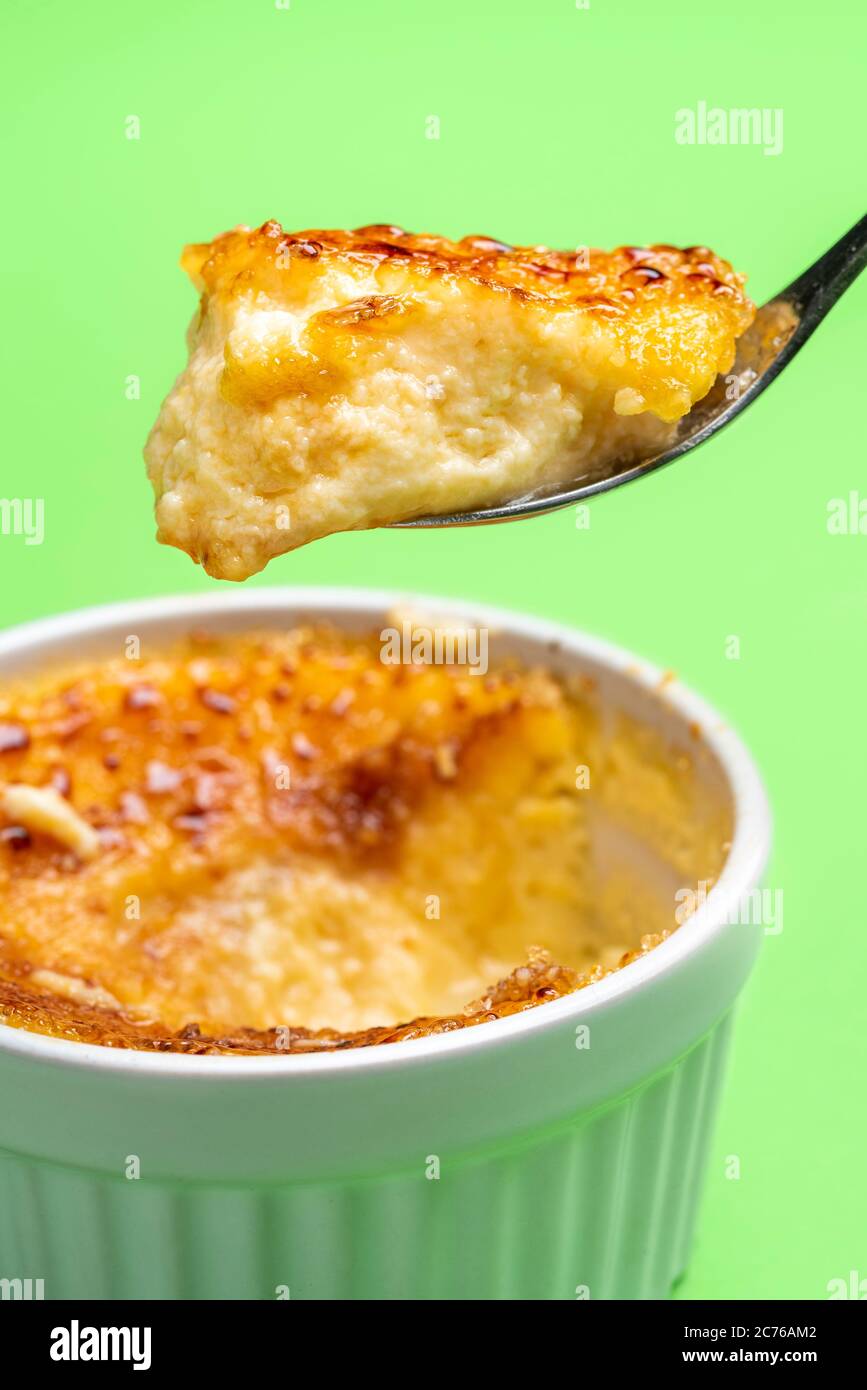 Burned cream french recipe close-up. Creme brulee on a spoon against a ...