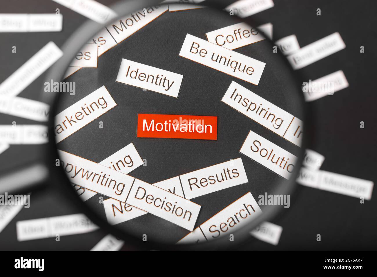 Magnifier glass over the red inscription motivation cut out of paper ...