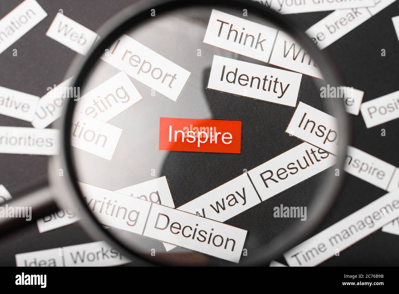 Magnifier glass over the red inscription inspire cut out of paper ...