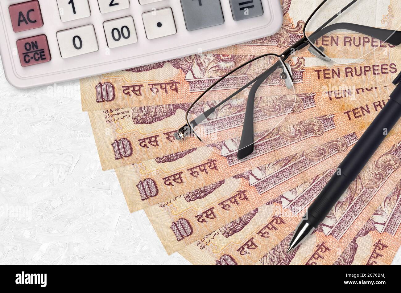 10 Indian rupees bills fan and calculator with glasses and pen ...