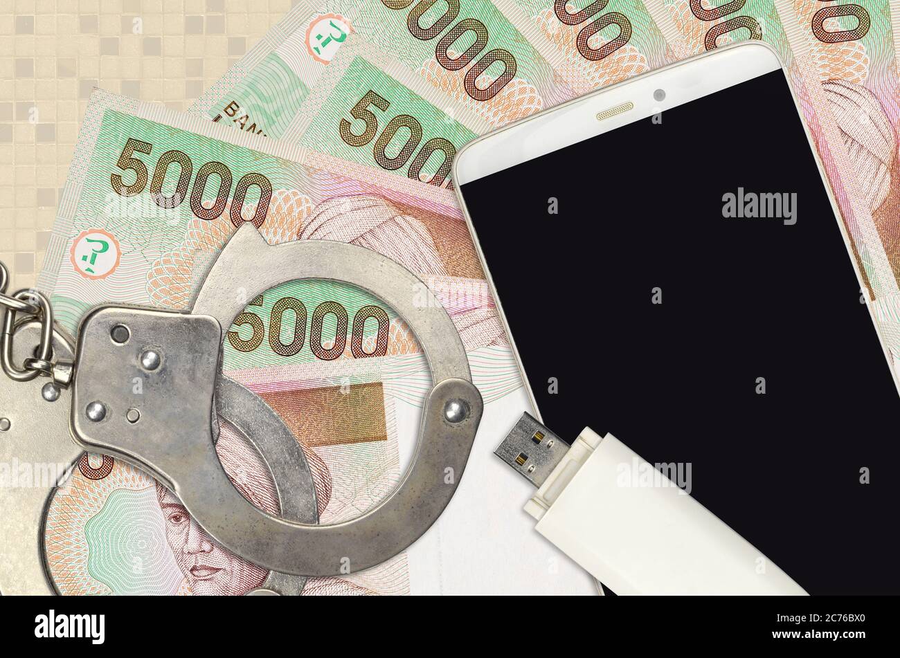 5000 Indonesian rupiah bills and smartphone with police handcuffs ...