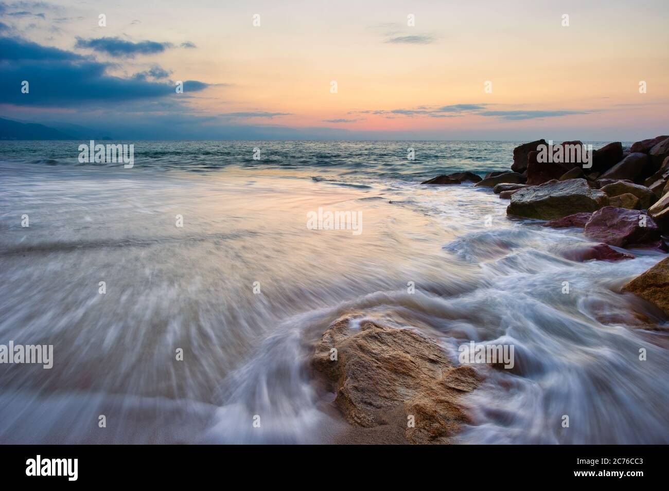 A Colorful Ocean Sunset Sky as a Gentle Wave Rolls to Shore Stock Photo ...