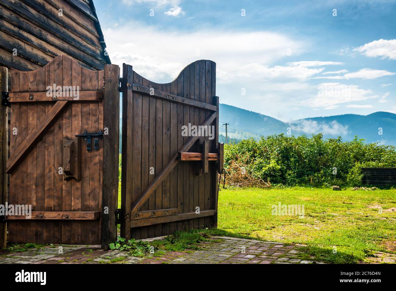 Rural wooden gate and green lawn with grass, mountains, blue sky Stock ...