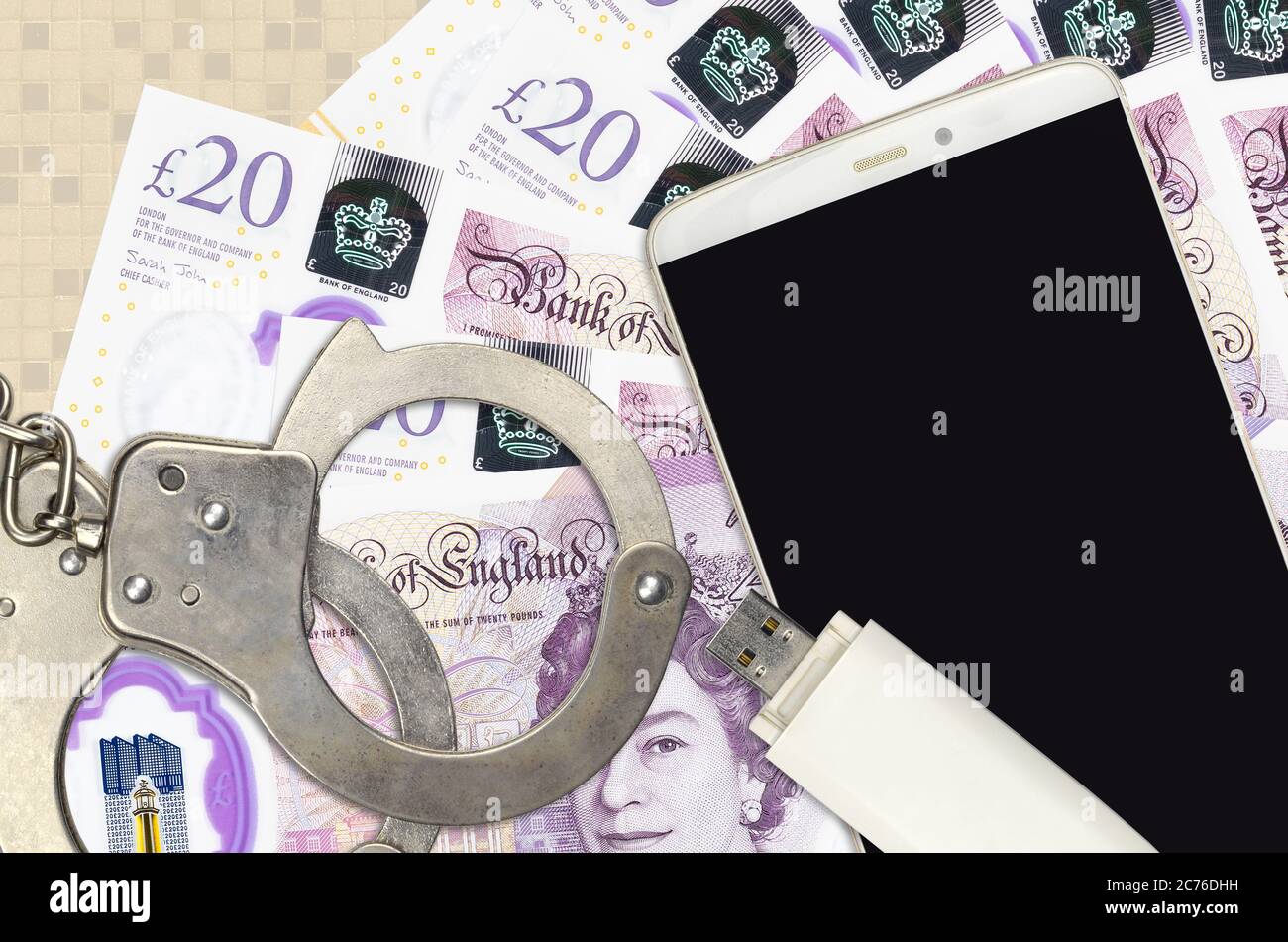 20 British pounds bills and smartphone with police handcuffs. Concept ...