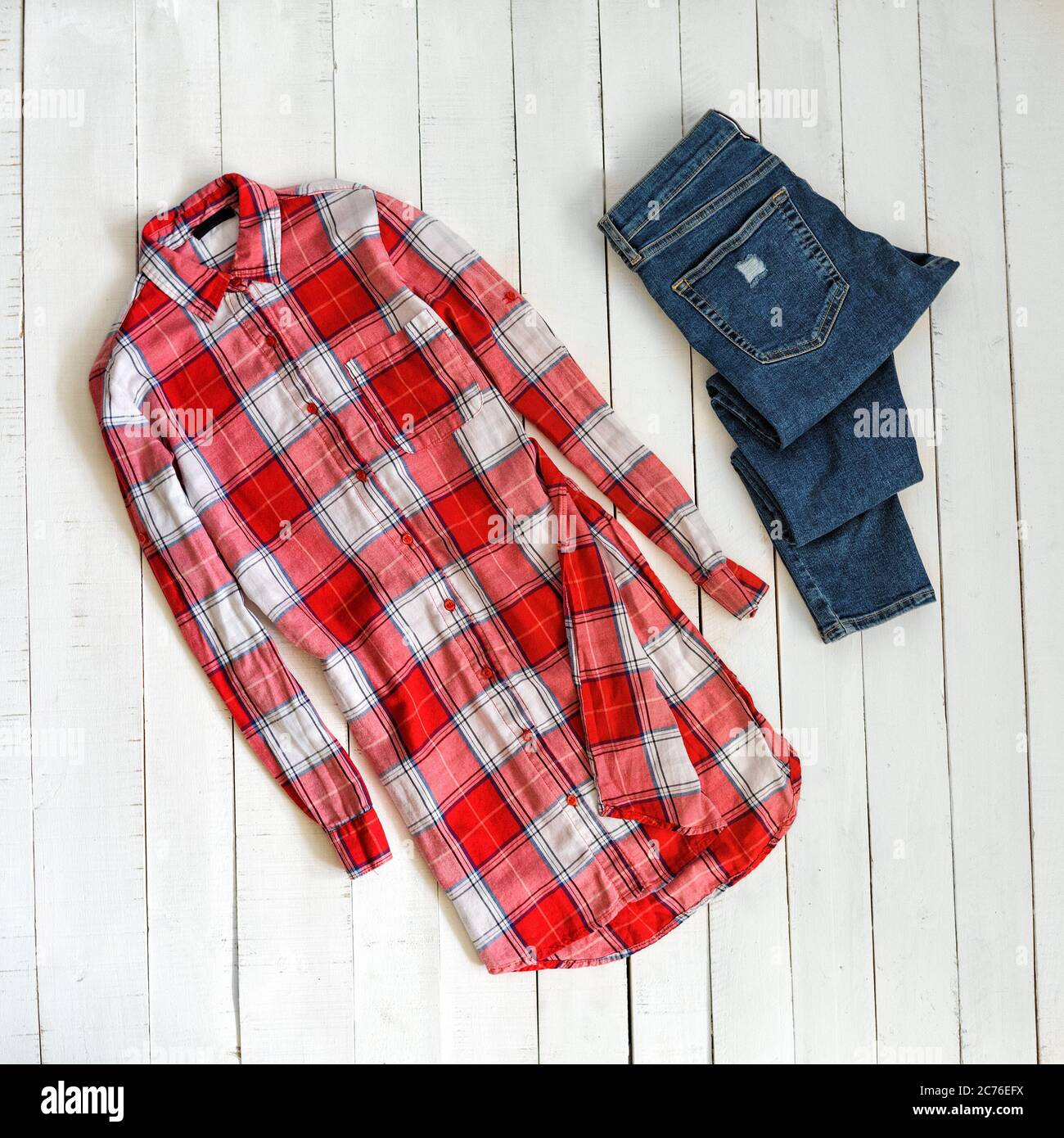 Clothes concept. Red and white checkered shirt and jeans on a wooden ...
