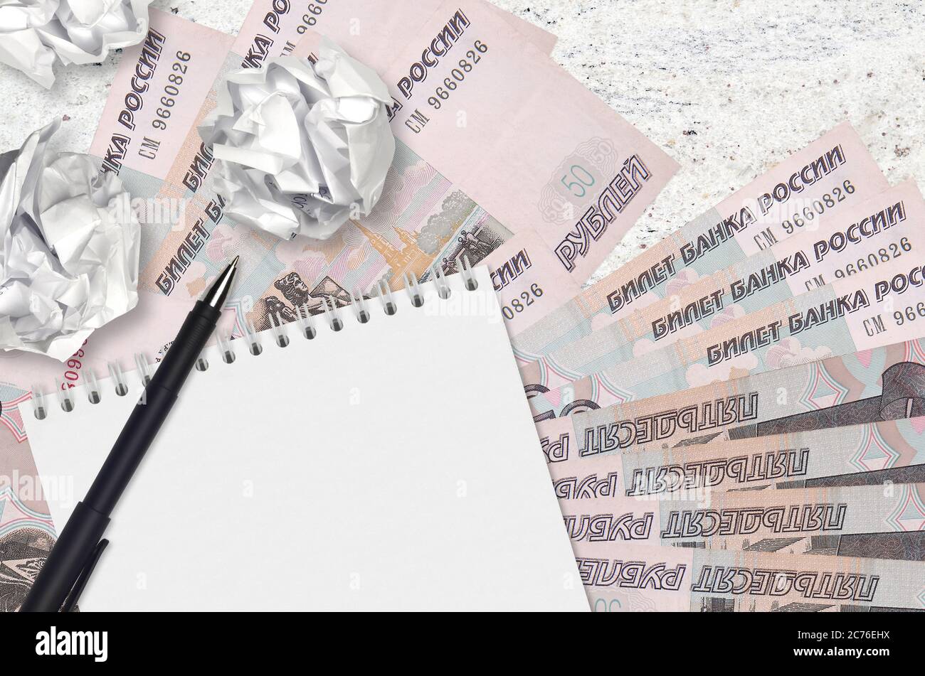 50 russian rubles bills and balls of crumpled paper with notepad. Bad ...