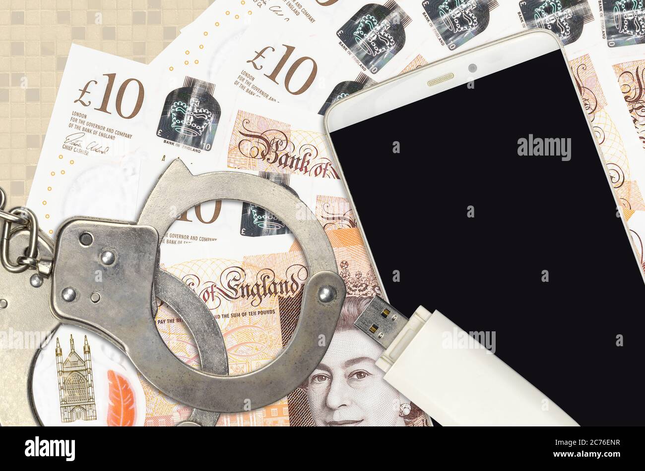 10 British pounds bills and smartphone with police handcuffs. Concept ...