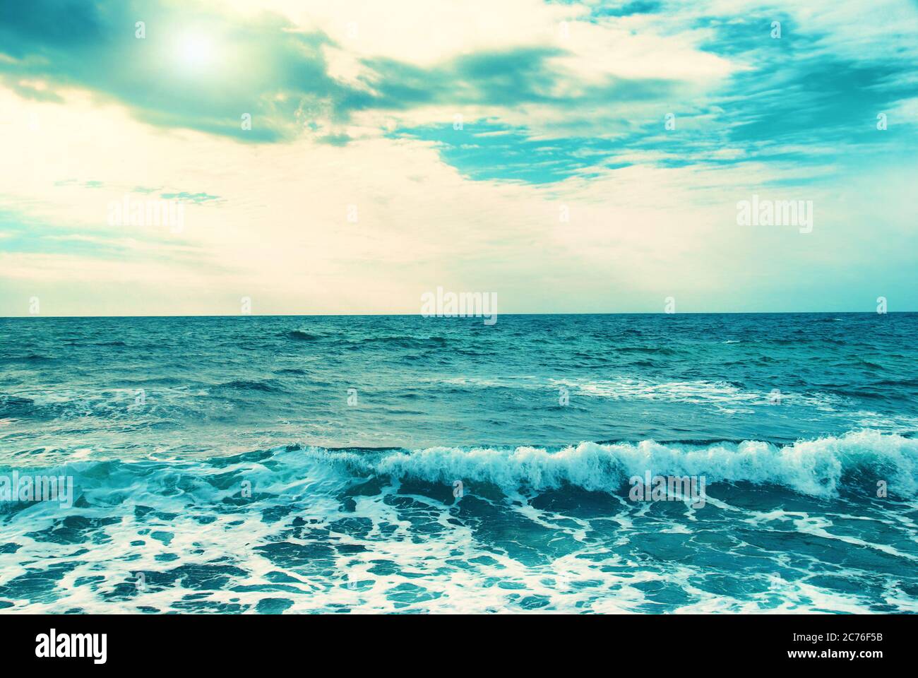 Blue sea- only shining sun, water, waves and clouds Stock Photo - Alamy