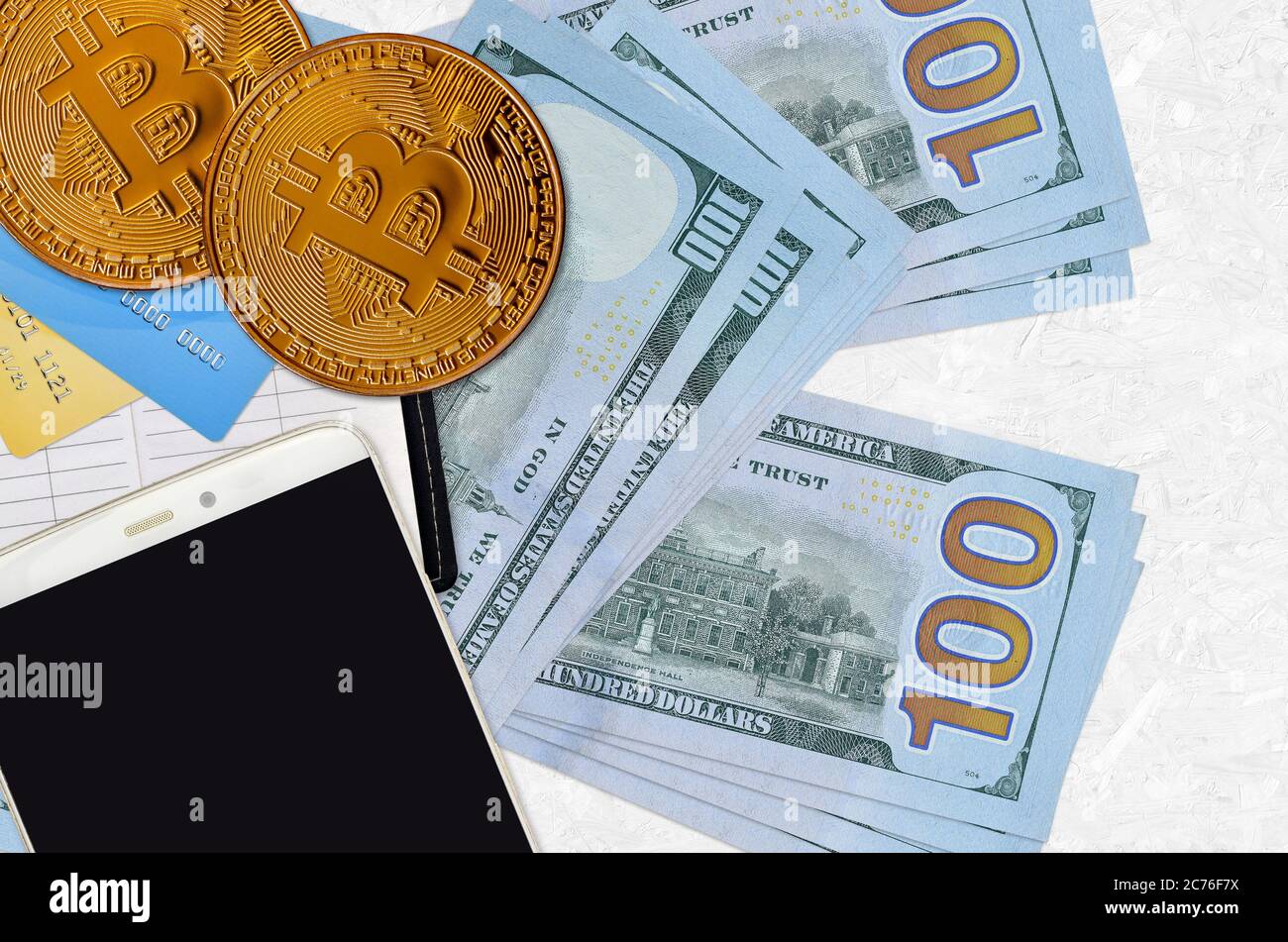 100 US dollars bills and golden bitcoins with smartphone and credit ...