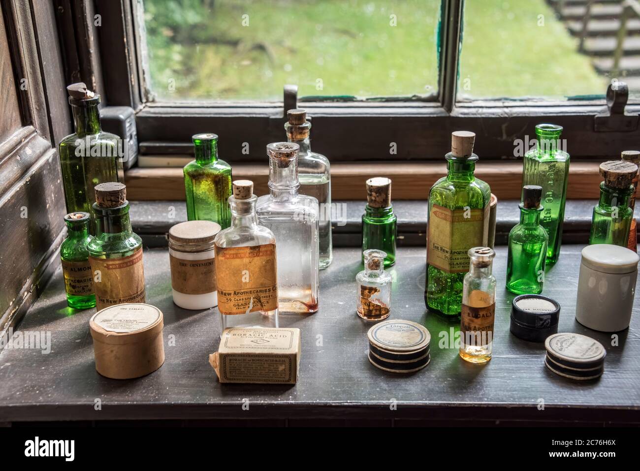 Window shelf with collection of old medicine bottles and containers ...