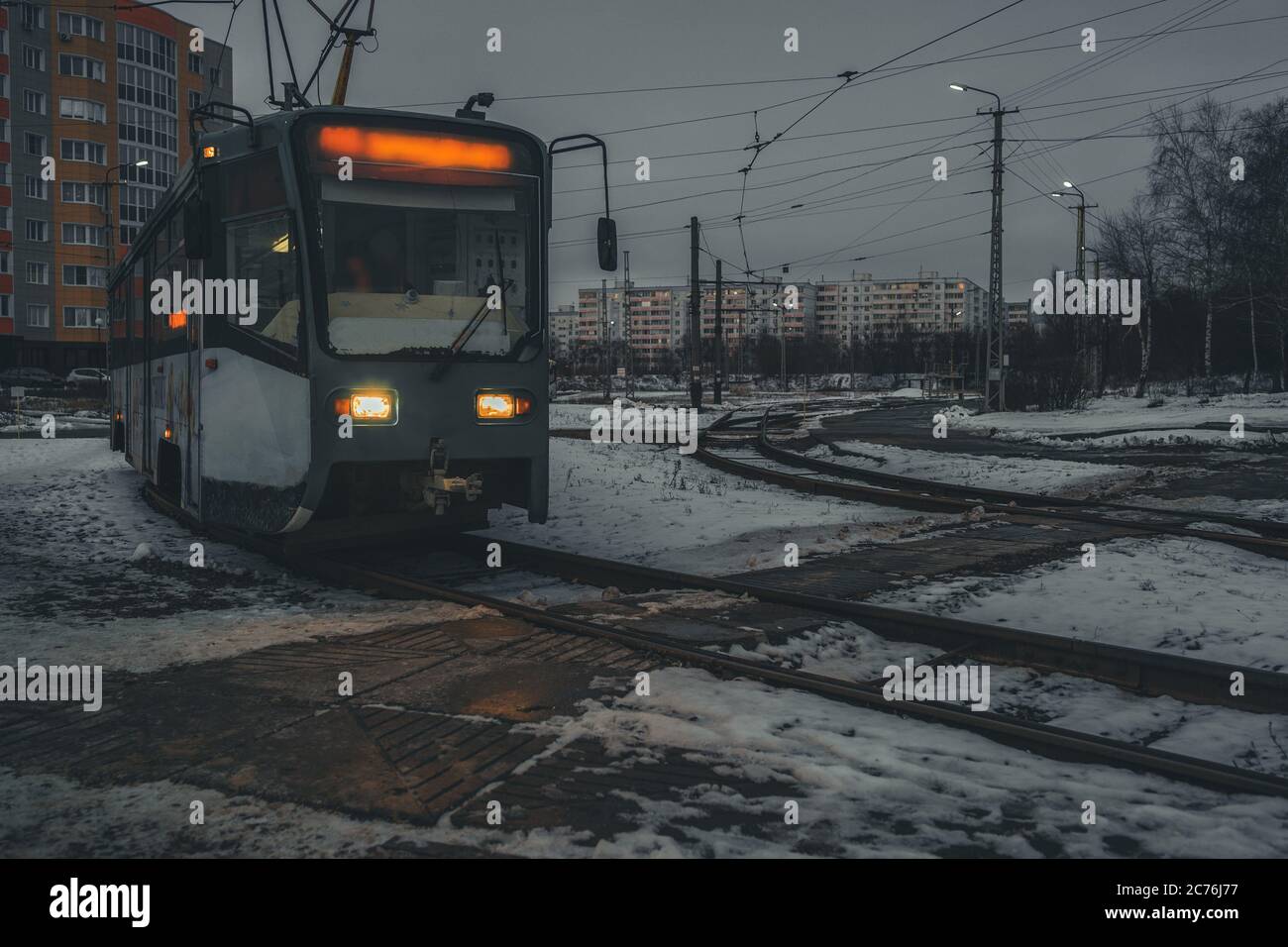 Modern tram in winter city in evening. Contemporary tram is on tram ...