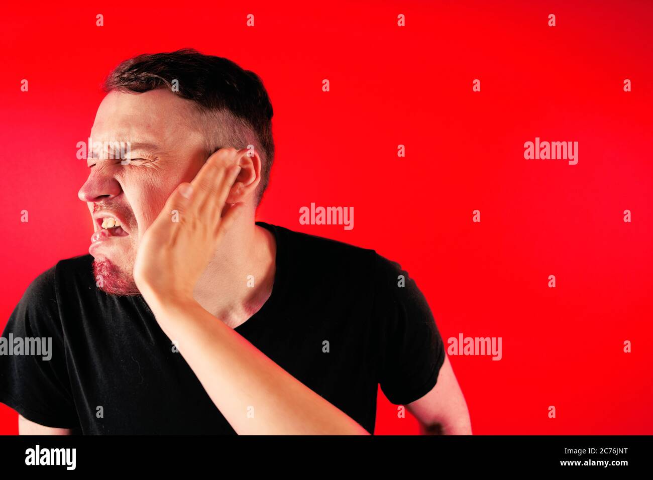 Man getting slapped on red background. Unhappy scared man getting ...