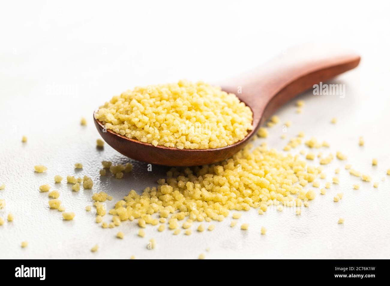 Dry yellow couscous in wooden spoon Stock Photo - Alamy