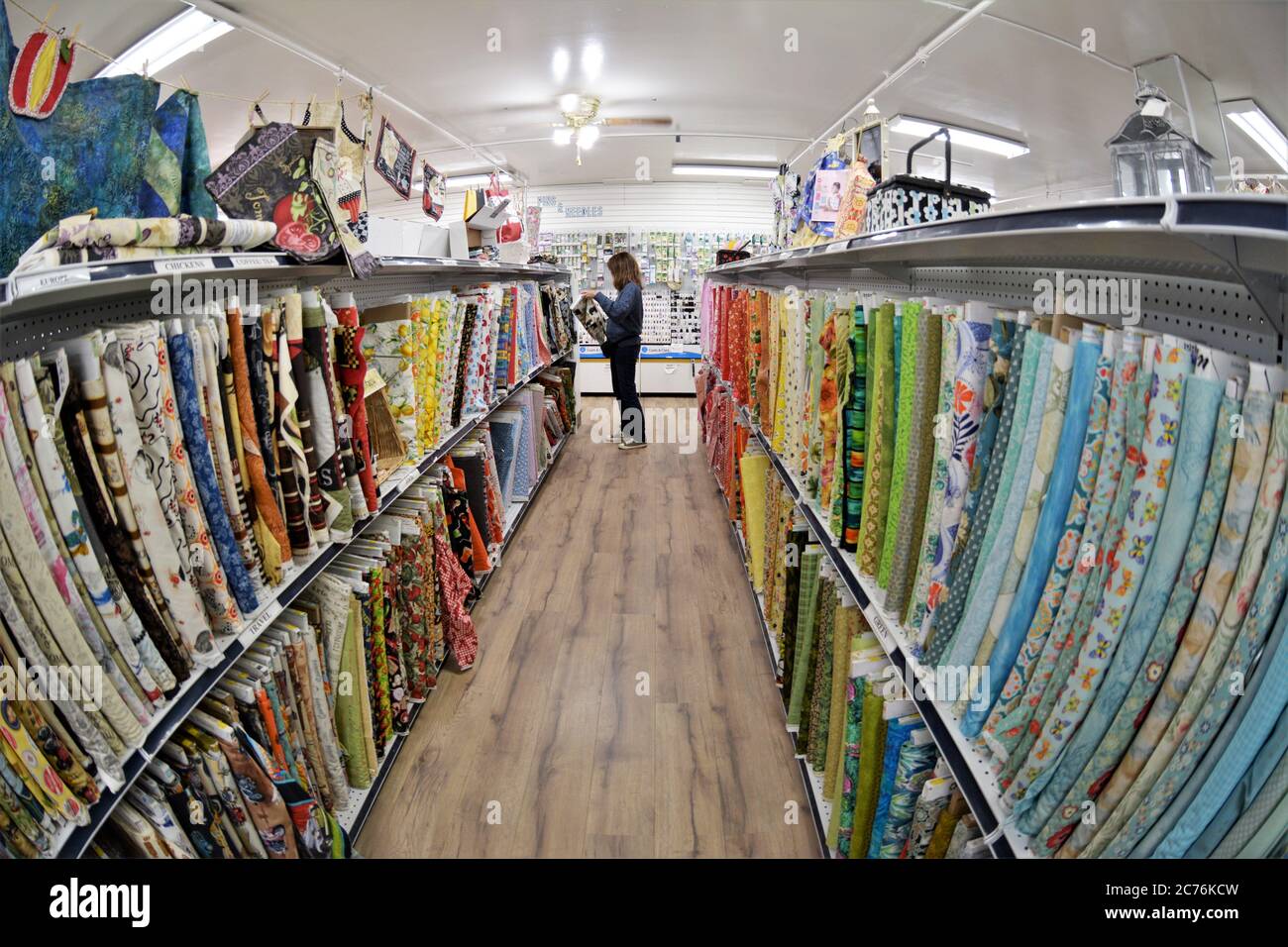 woman shopping in fabric and cloth store for material to cover a chair ...