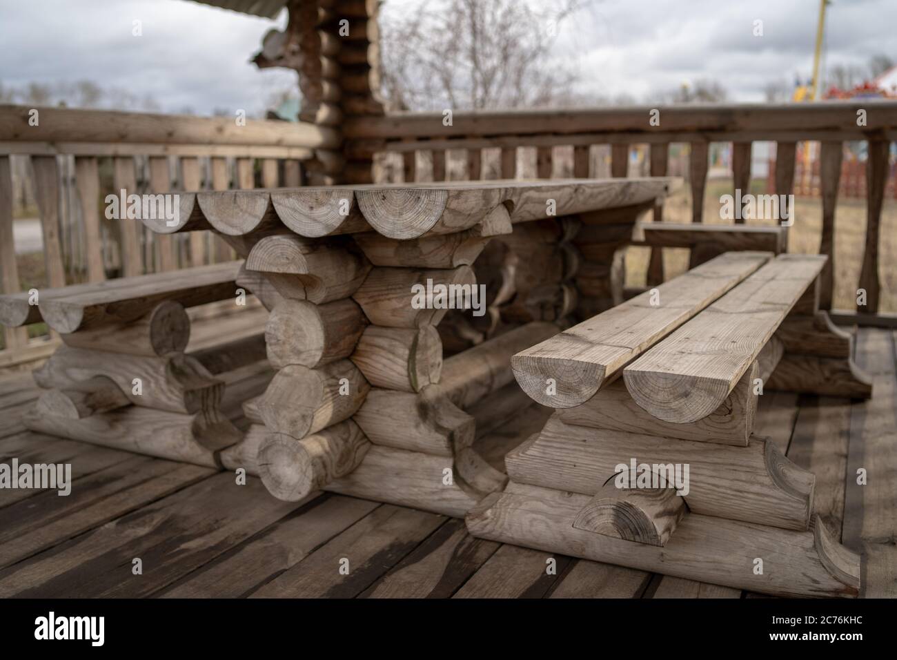 Wooden table with benches in amusement park. Fenced terrace with log ...