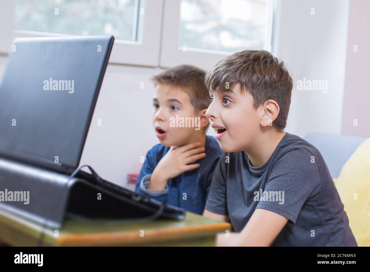 two little boys enjoying using internet on laptop Stock Photo - Alamy