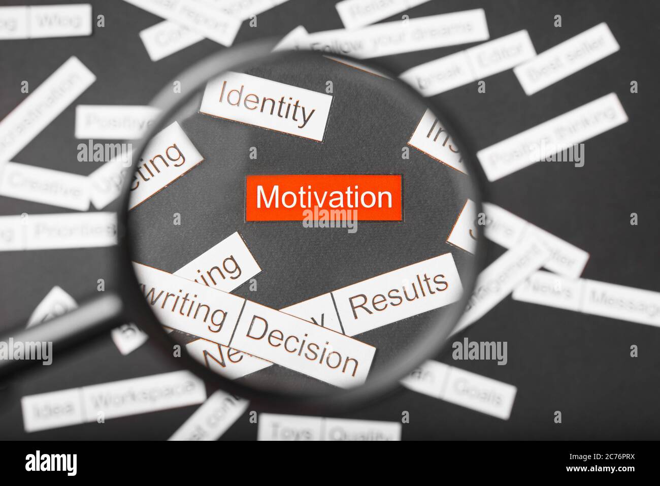 Magnifier glass over the red inscription motivation cut out of paper ...