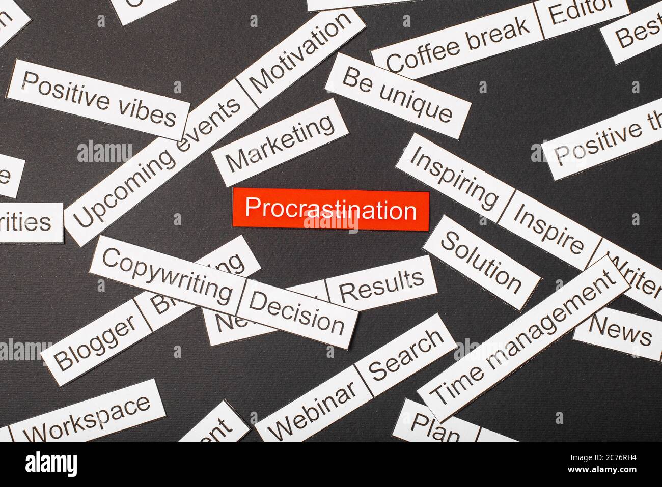 Cut paper inscription procrastination on a red background, surrounded ...