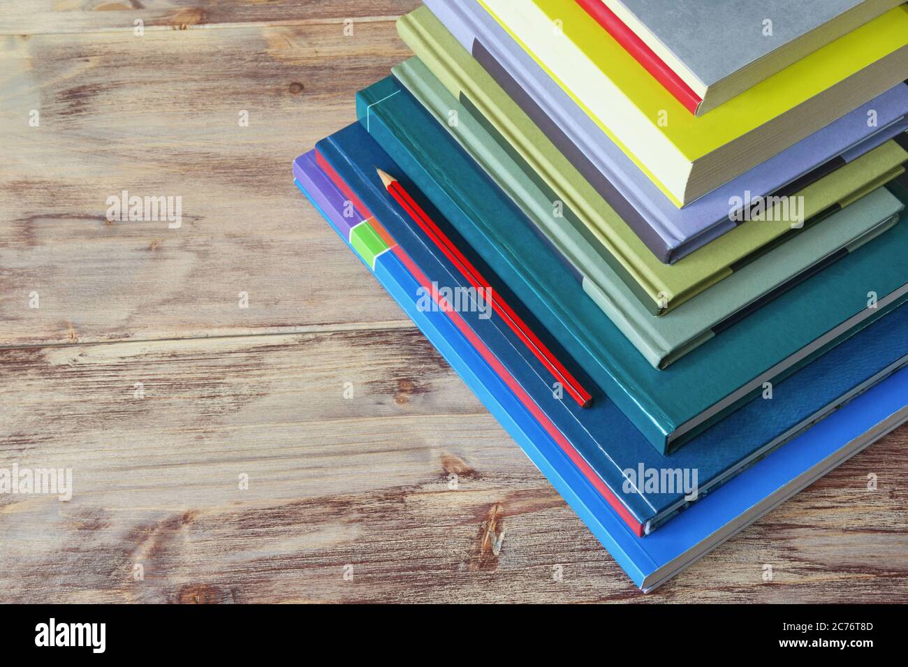 Stack of books of different sizes and colors on rustic background, free ...