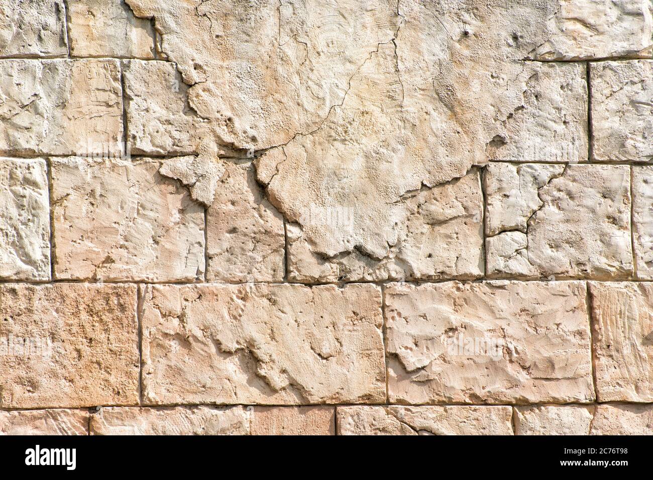Old gray wall of rectangular stone blocks with remnants of plaster ...