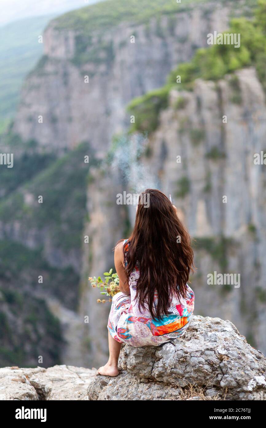 Young woman smoking a cigarette in the canyon Stock Photo - Alamy