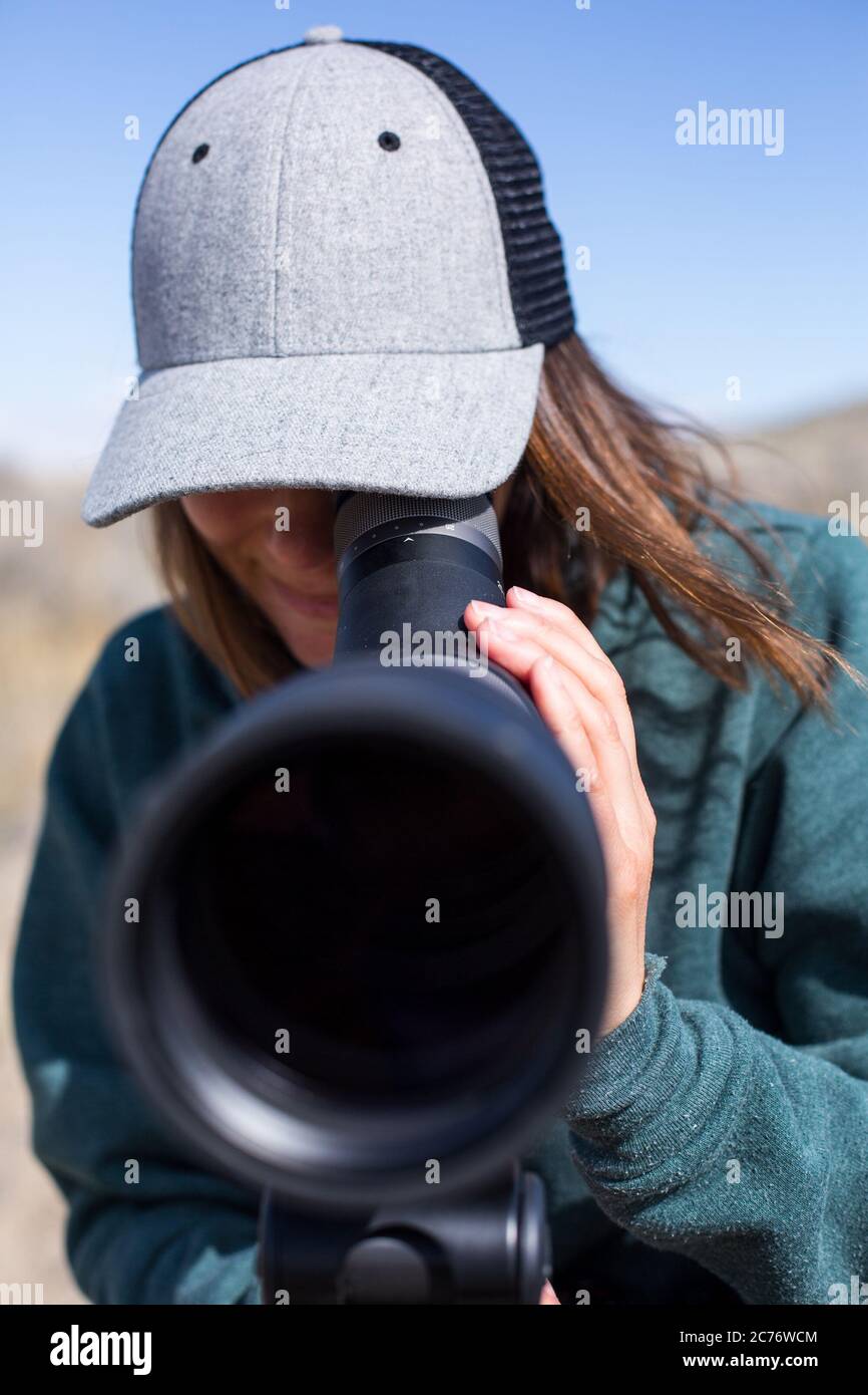 Woman looking through spotting scope, Wyoming, USA Stock Photo - Alamy