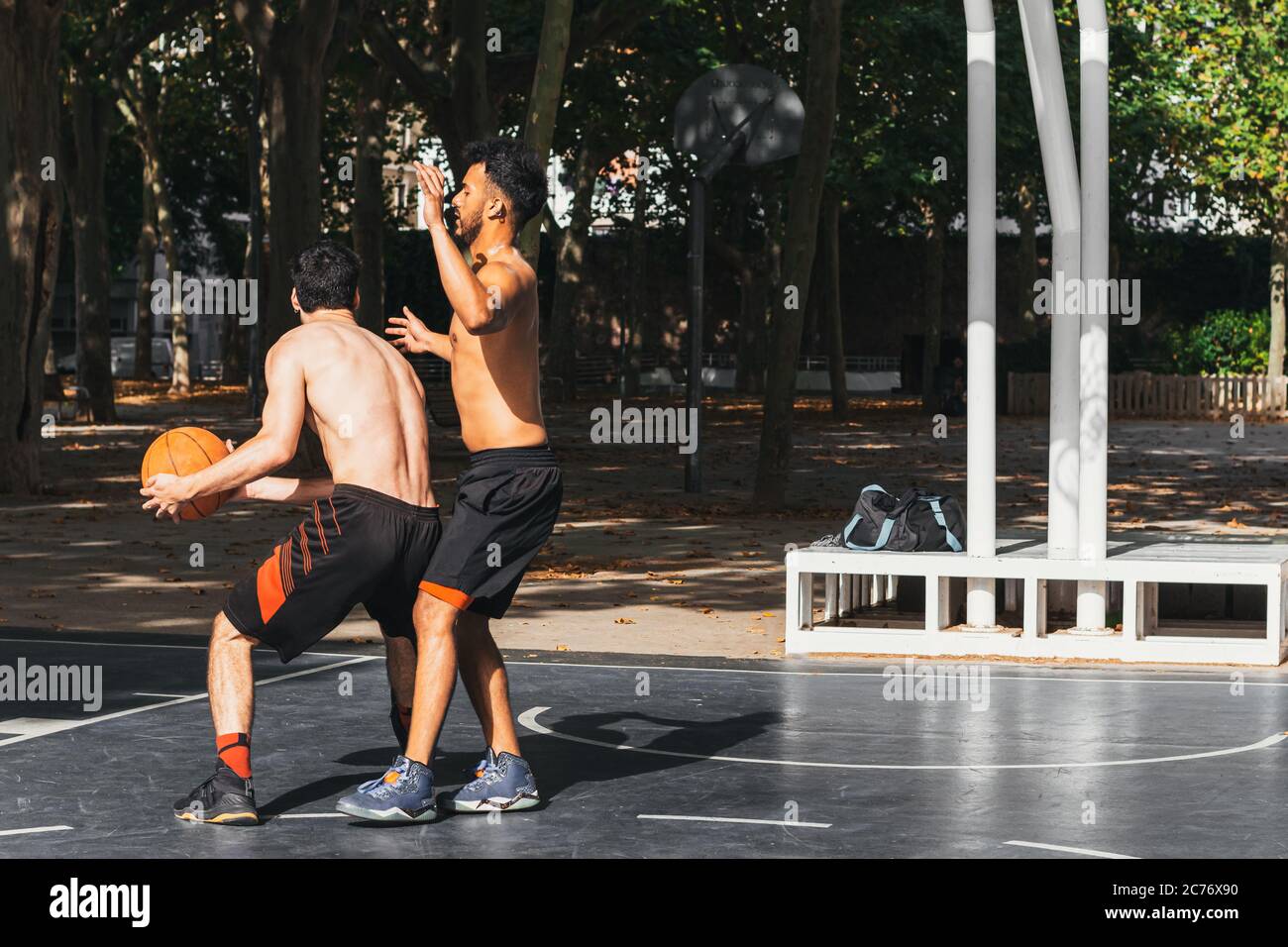 two young men playing basketball outdoors Stock Photo - Alamy