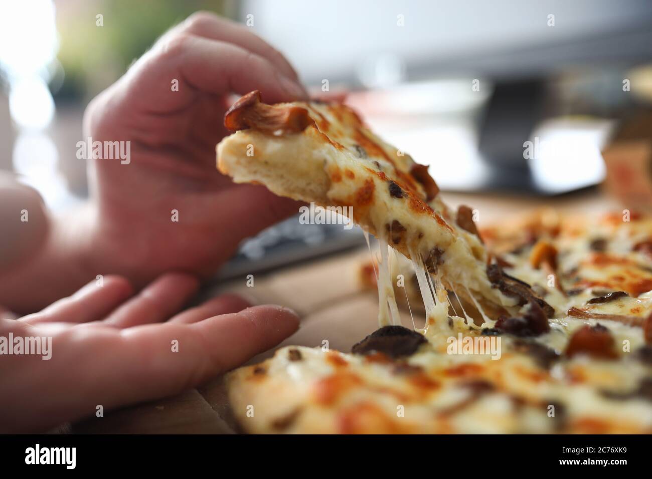 Male arms taking big piece of crusty fresh pizza Stock Photo - Alamy