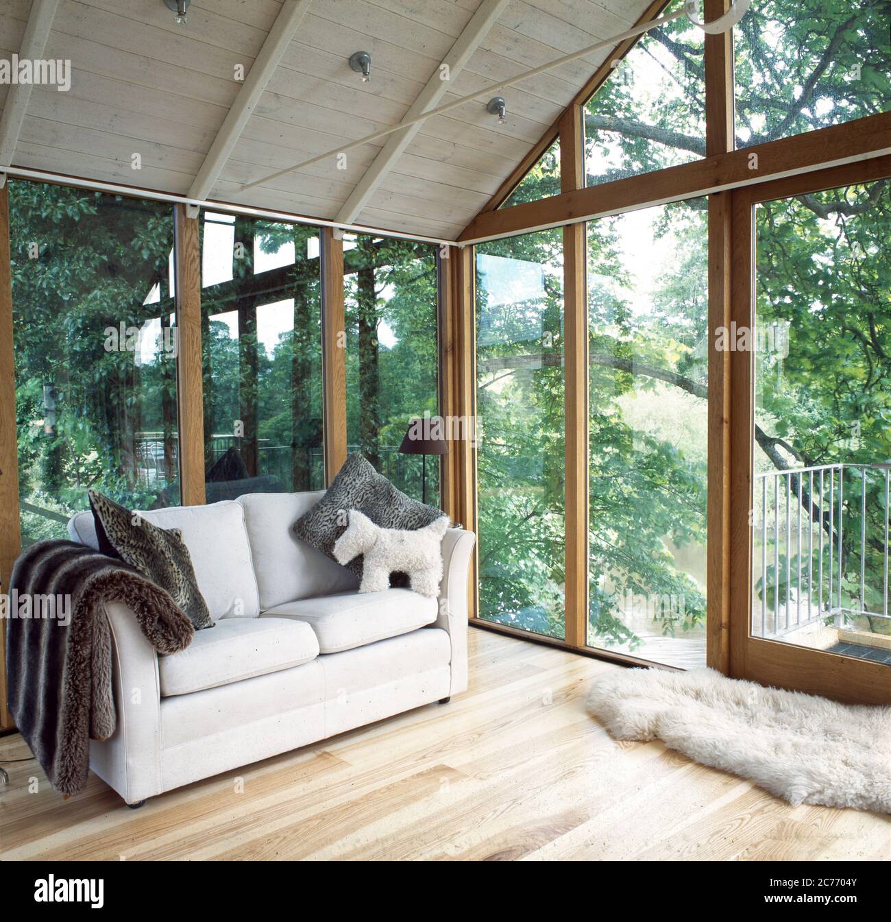 Glass garden room overlooking wooded area Stock Photo - Alamy