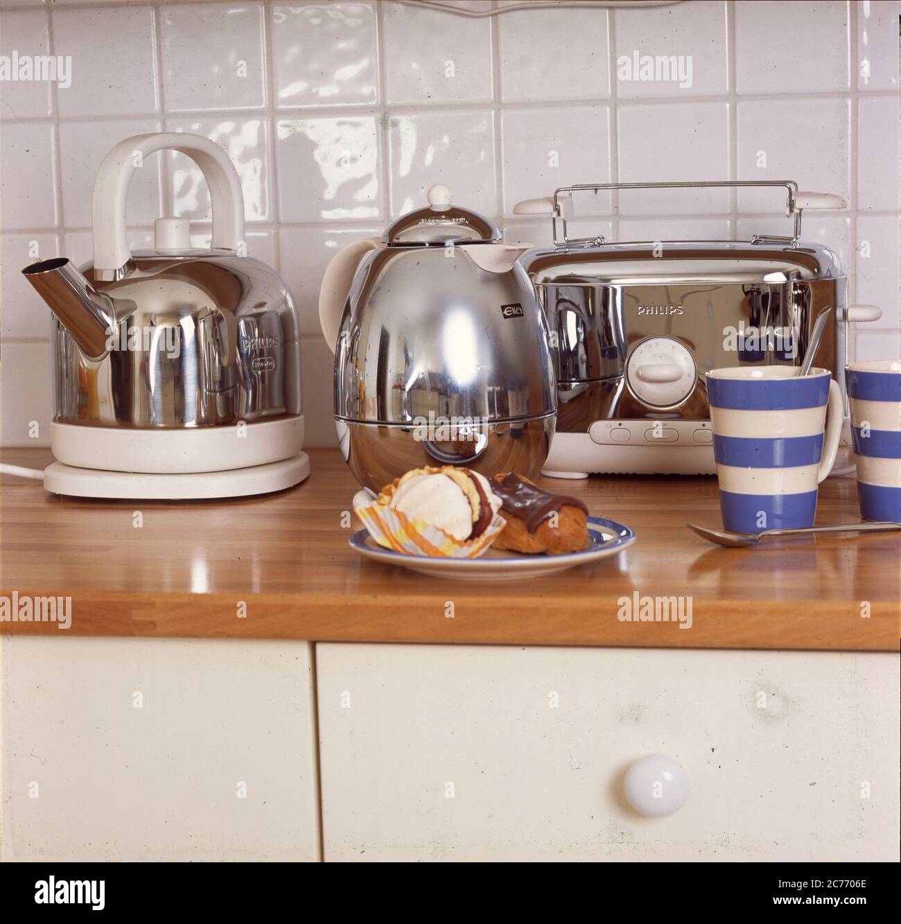 Closeup of kitchen counter with kettle, toaster, mugs and cakes Stock ...