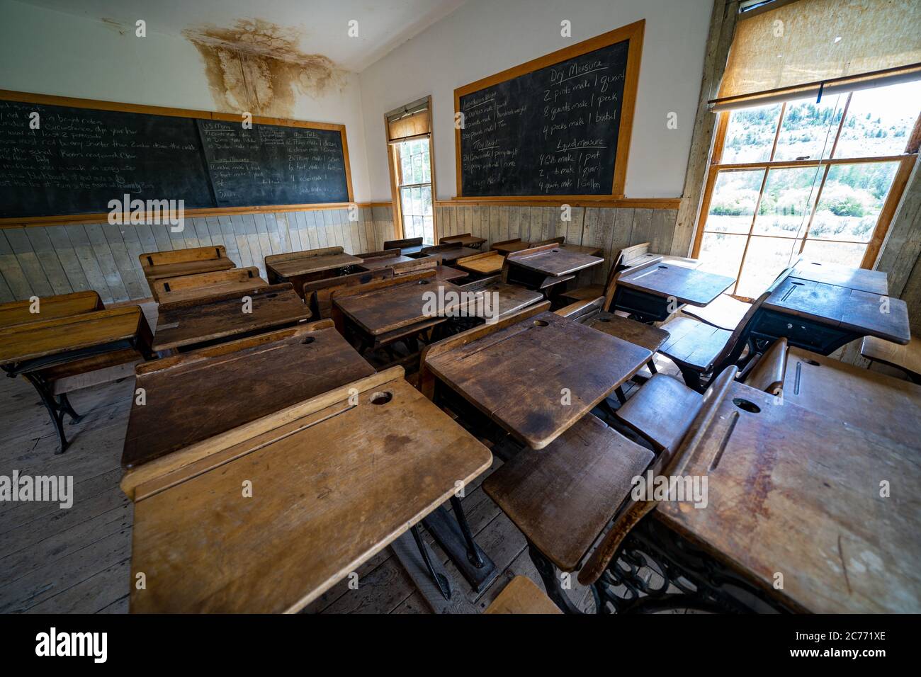 Bannack, Montana - June 29, 2020: Inside the old restored schoolhouse, with desks and a ...