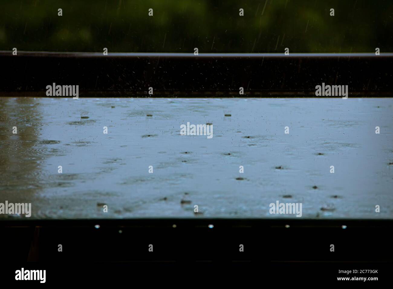 rain drops falling into a water puddle with water splashing Stock Photo ...