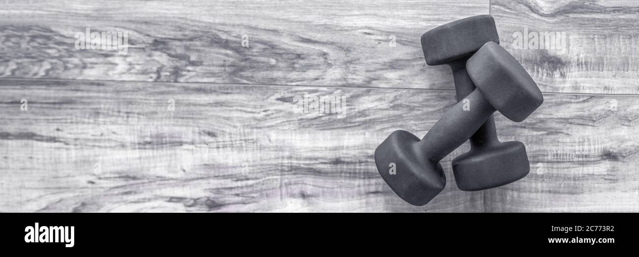 Strength training exercise gym concept: dumbbell weights on wood floor ...