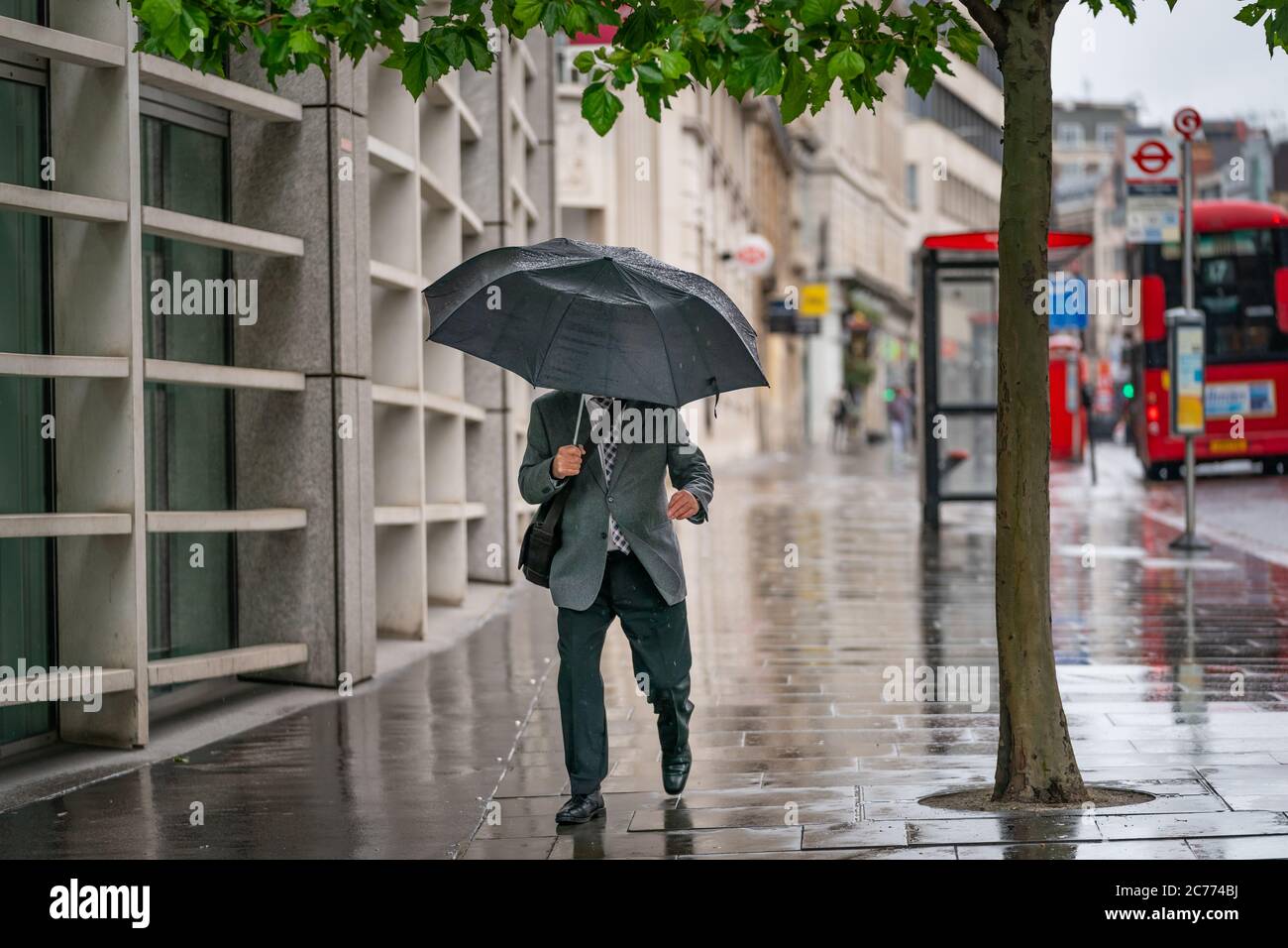Middle-aged businessman wearing a suit caught out in the rain during a ...