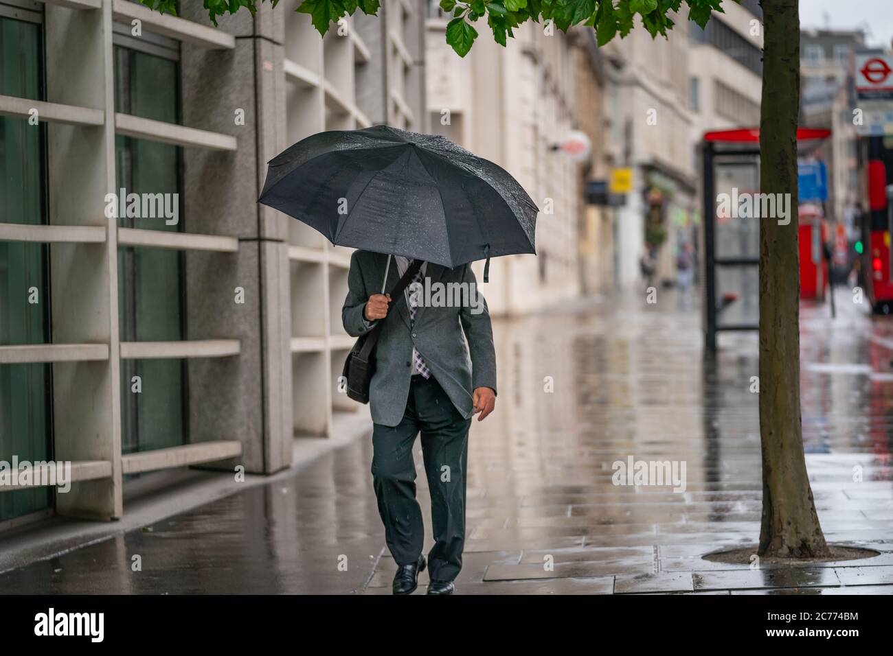 Middle-aged businessman wearing a suit caught out in the rain during a ...