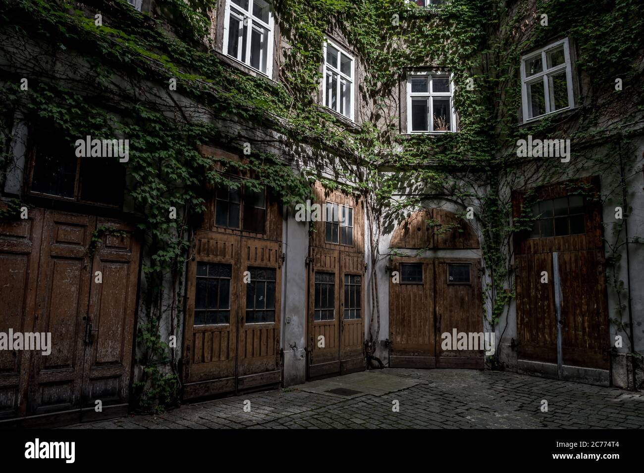 Courtyard Of A HIstoric Building With Wooden Doors And Ivy Overgrown ...