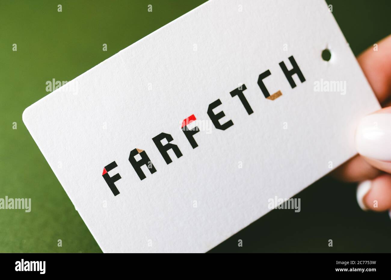 Hands holding Farfetch logo on green background Stock Photo - Alamy