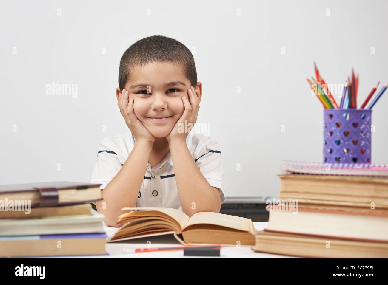 Bored schoolboy. A boy looking tired of doing homework. Mixed-race kid ...