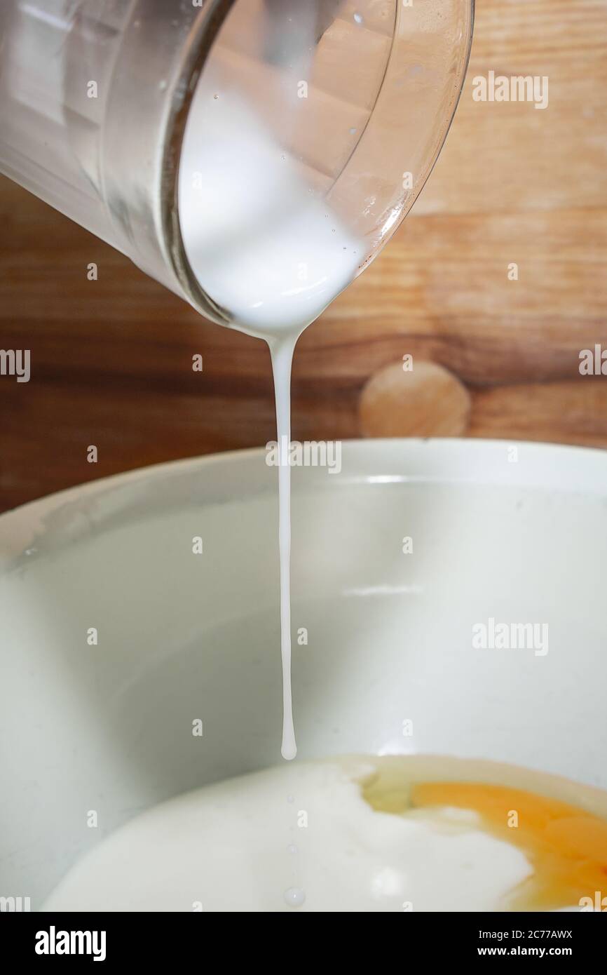The process of cooking. The cook pours milk into the dough. Home baking ...