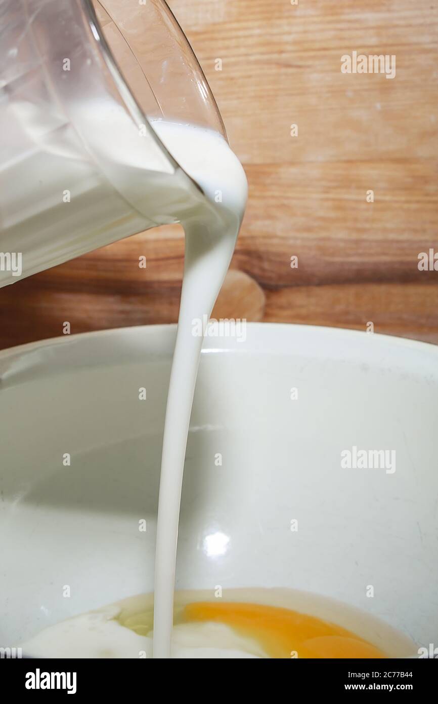 The process of cooking. The cook pours milk into the dough. Home baking ...