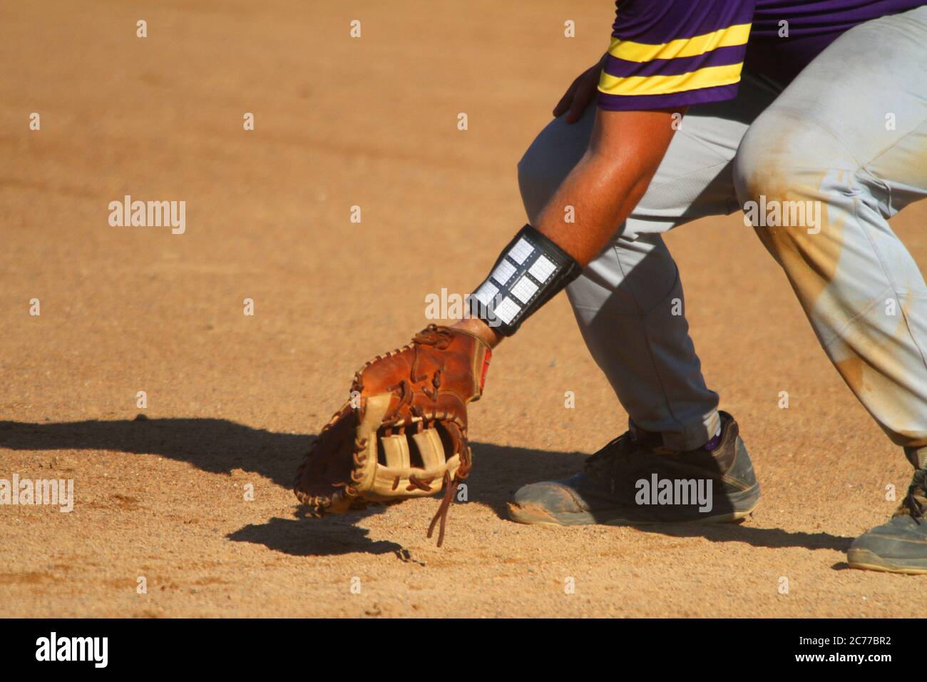 A baseball first baseman is crouched and ready to make a play in a ...