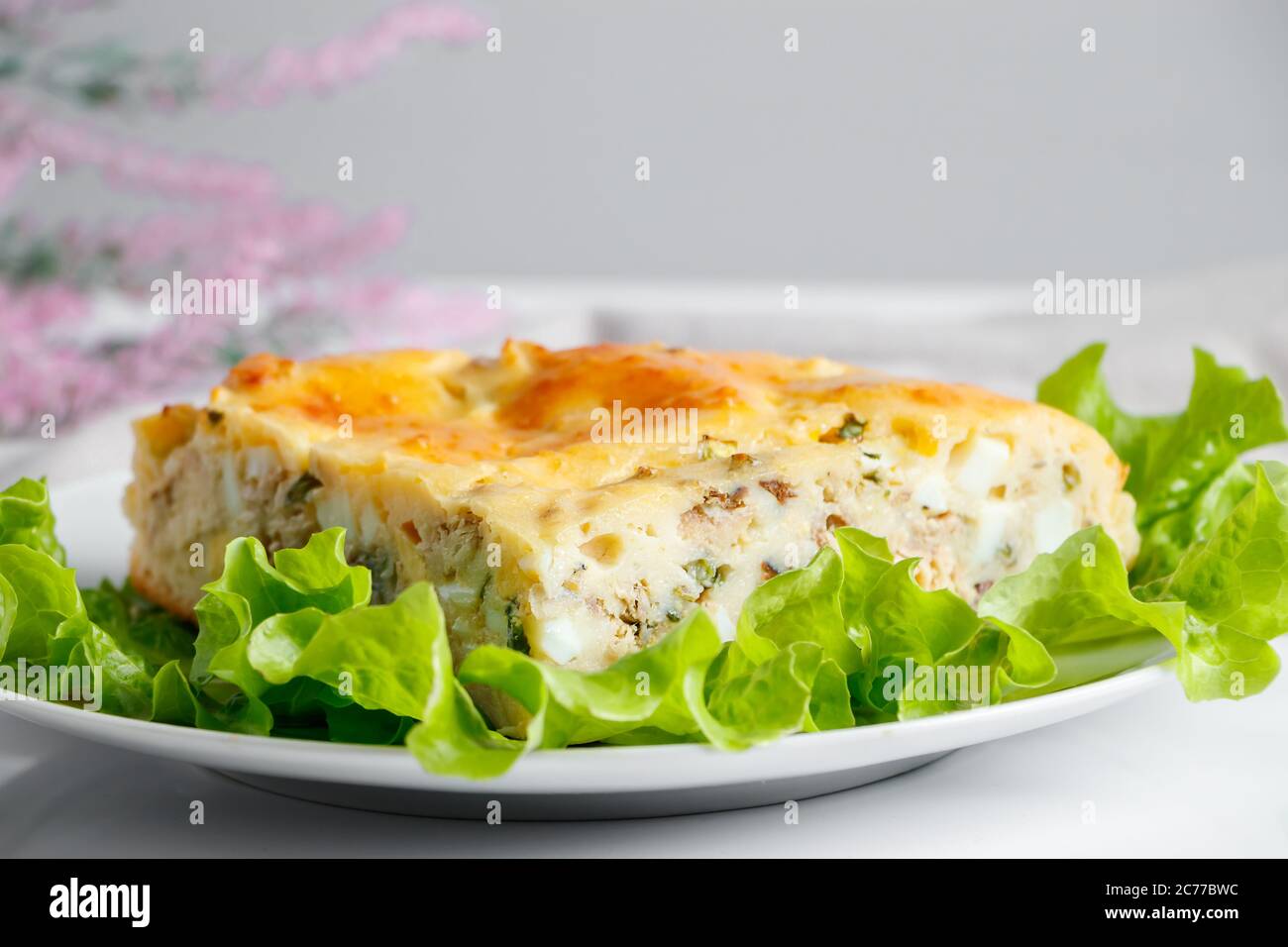 Tasty fish pie on a plate. A piece of cake with mackerel and greens on ...