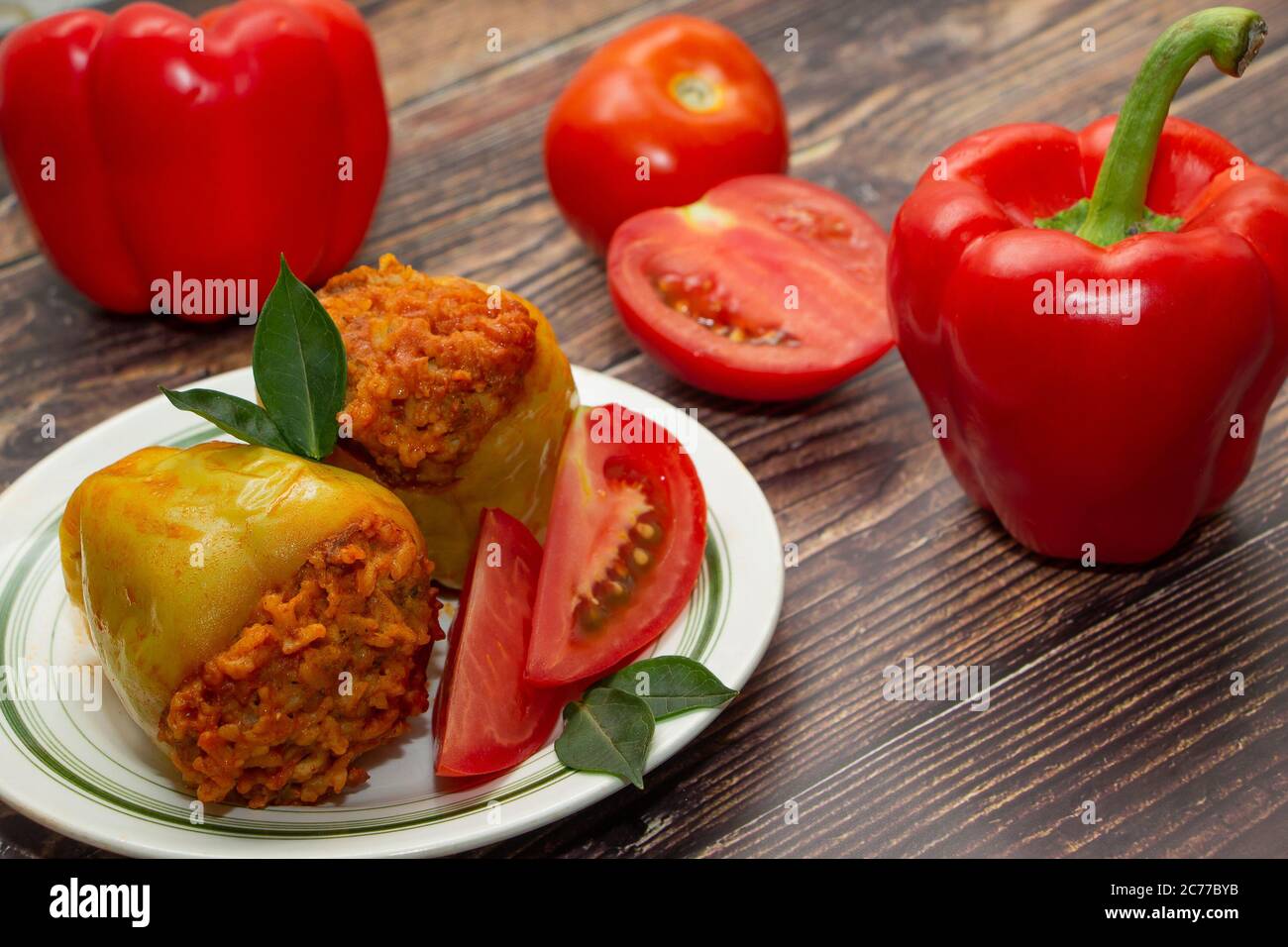 Red and yellow peppers with meat on a wooden background Stock Photo - Alamy