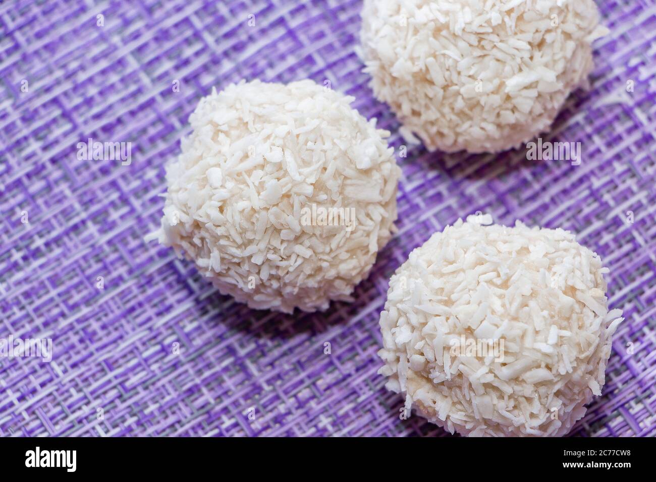 Coconut homemade candy on purple background close-up Stock Photo - Alamy