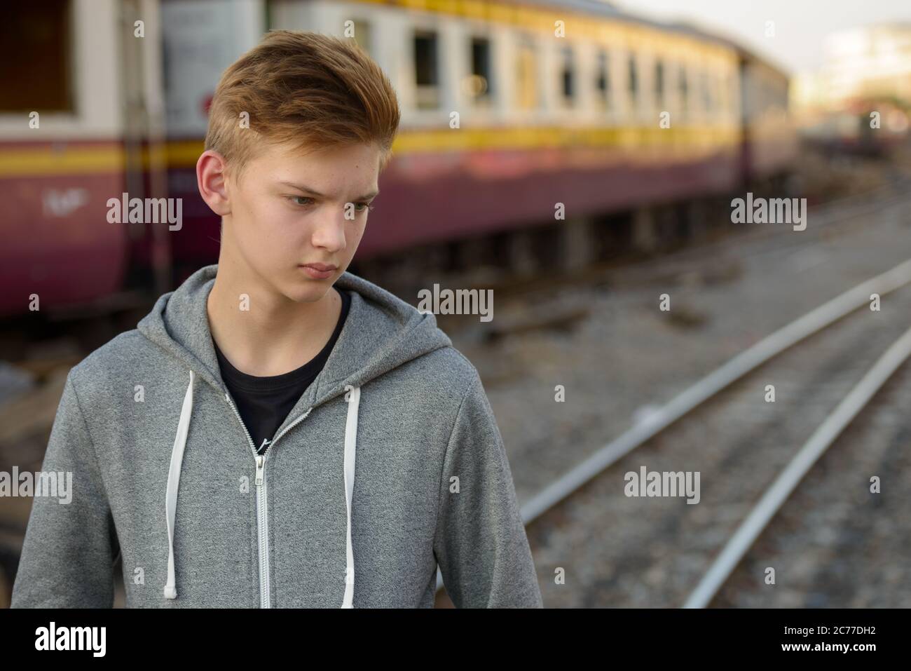 Young handsome teenage boy at the railway train station Stock Photo - Alamy